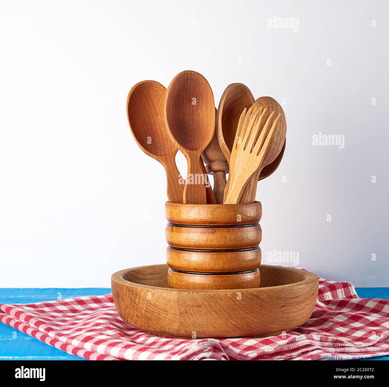 wooden spoons in a wooden container on a blue table, kitchen backdrop ...