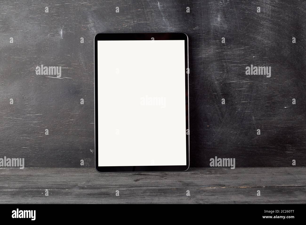 electronic tablet with a blank white screen against a black chalk board ...