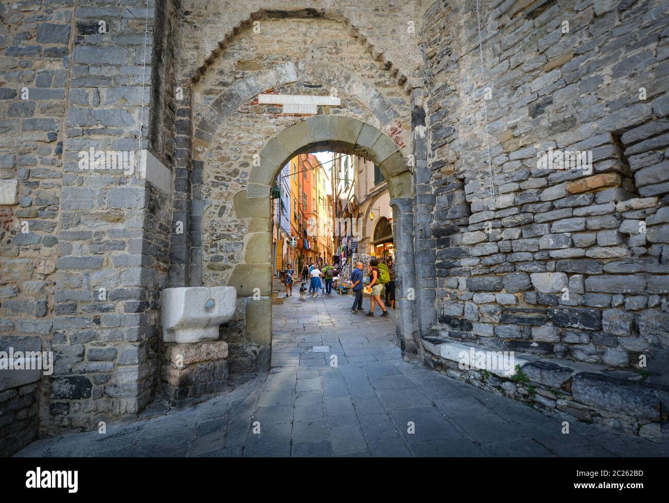 Tourists sight-see and shop inside the ancient town gate of the coastal ...