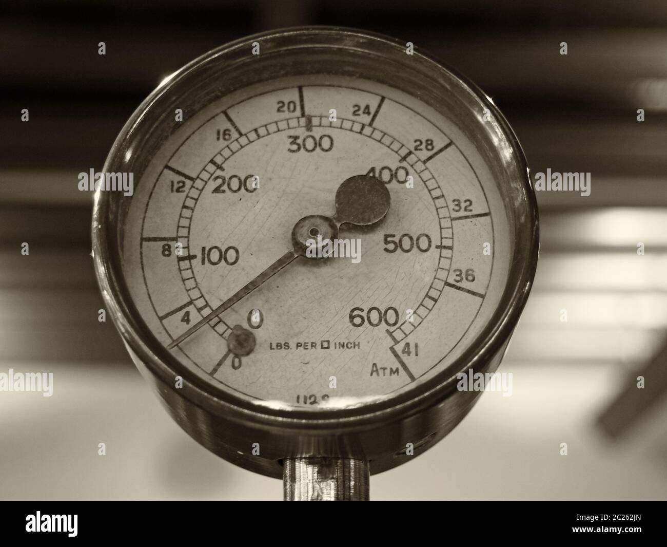 sepia monochrome image of an old shiny brass round pressure gauge with ...