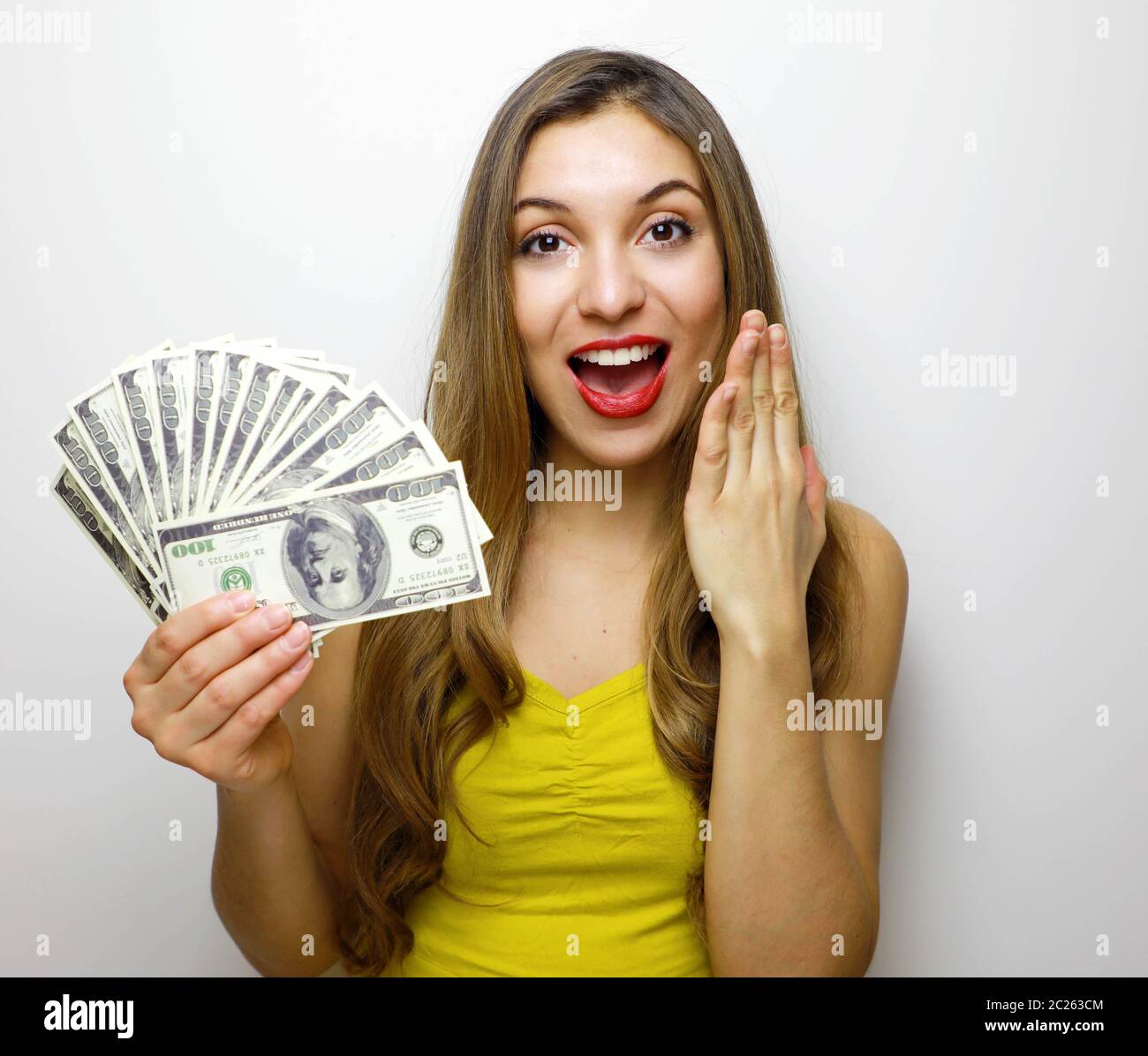 Portrait of a shocked pretty girl looking at camera with money ...