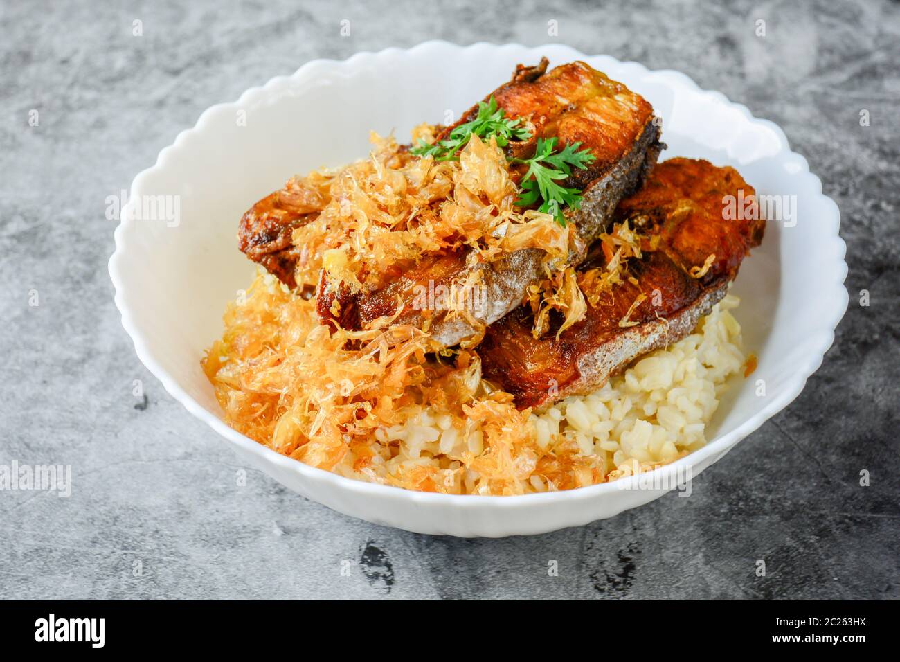 Deep fried sliced Pangasius fish with garlic, served with brown rice ...