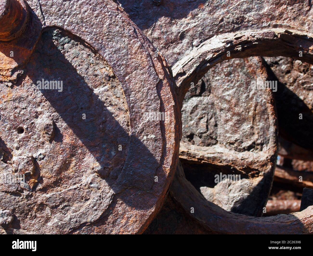 corroded iron wheels covered in brown rust on old industrial machinery ...