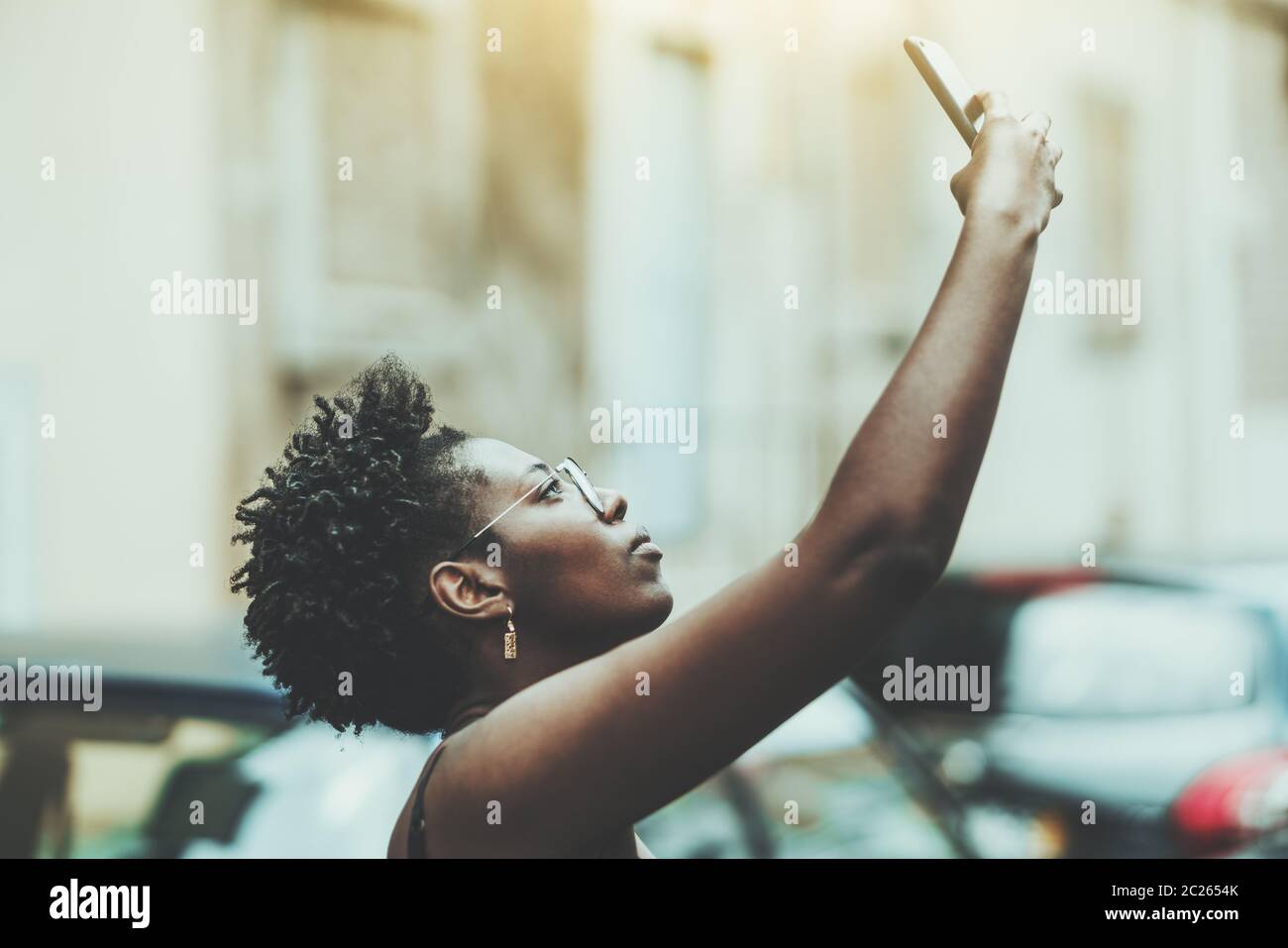 Portrait of a charming black tourist woman shooting sightseen on the ...