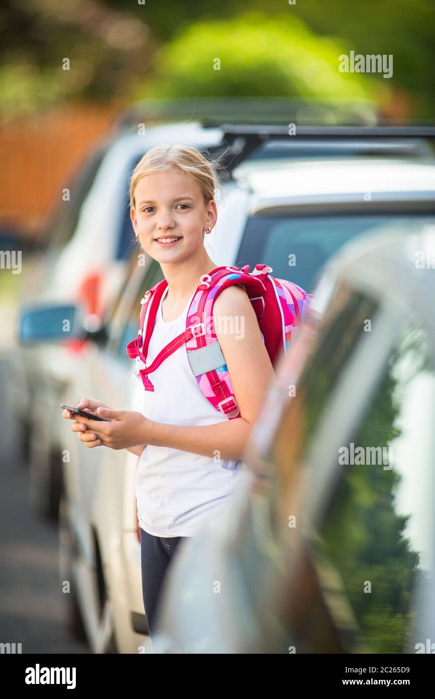 Cute little girl going home from school, looking well before crossing ...