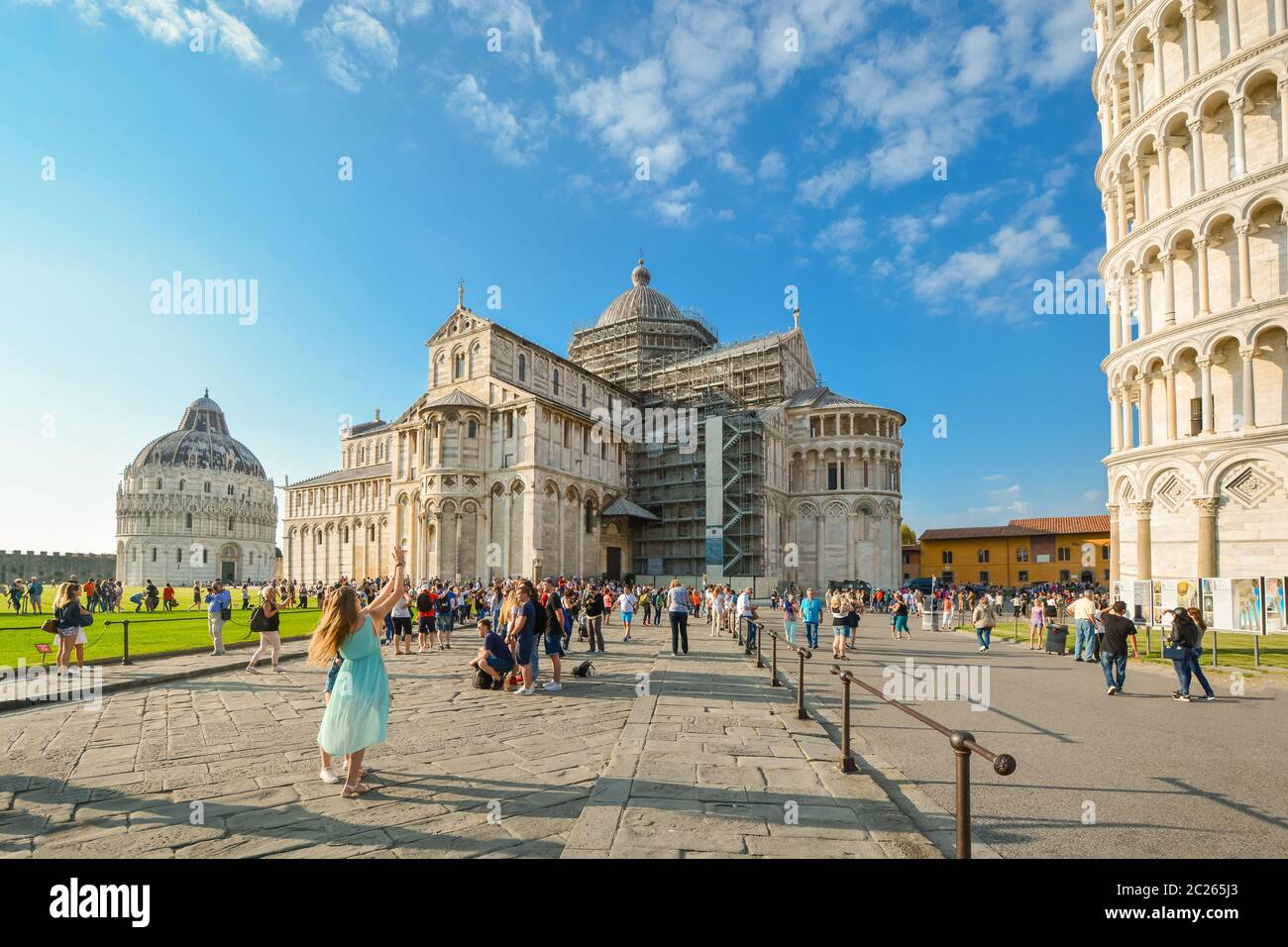 A female tourist poses in front of the Leaning Tower of Pisa with the ...