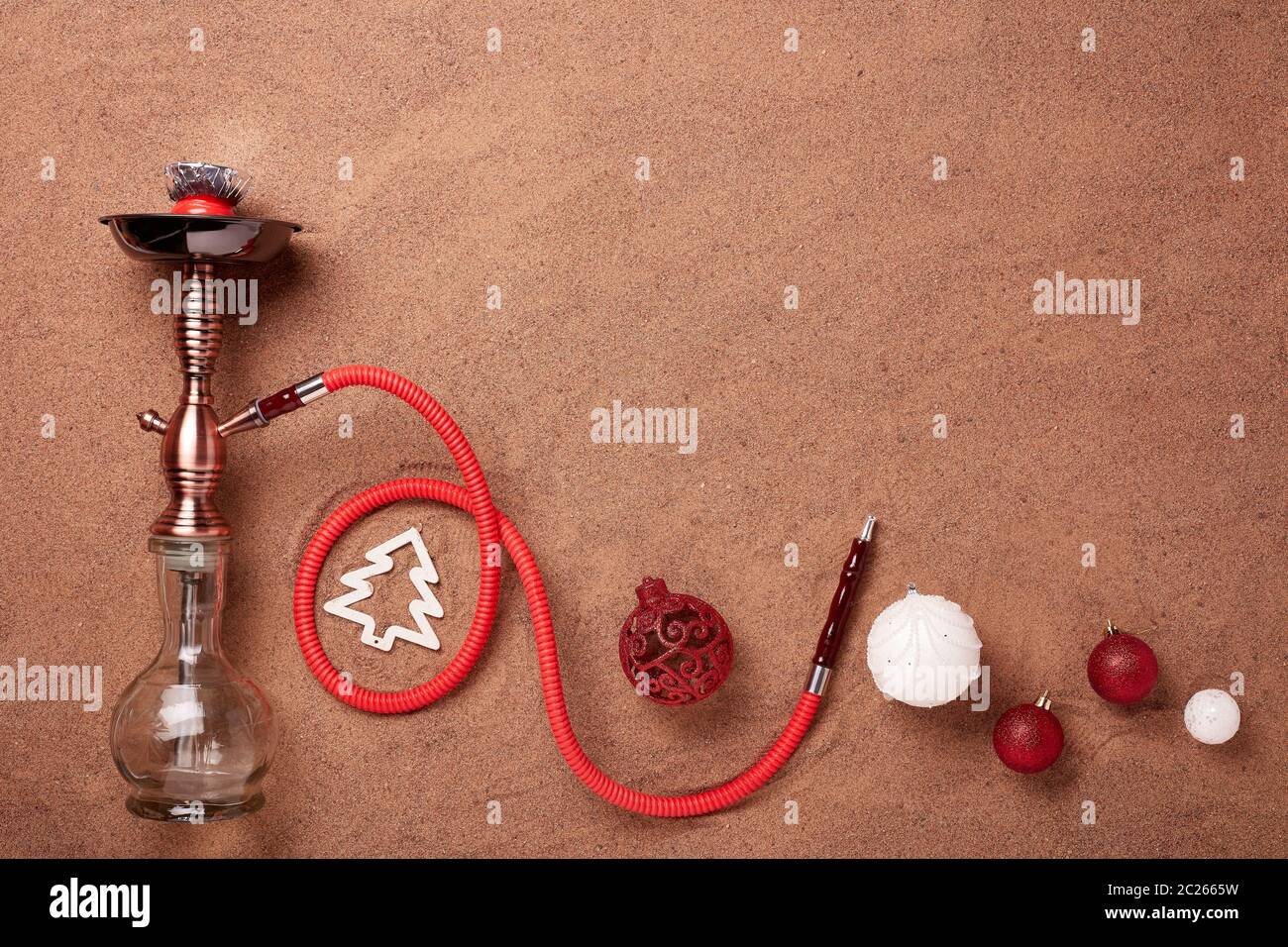 Hookah (shisha) and christmas ornaments on sand background. Top view ...
