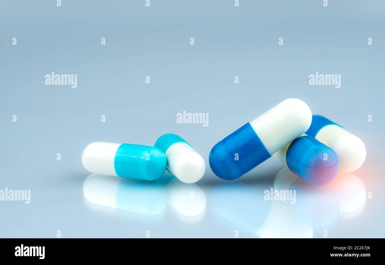 Blue and white capsules pill isolated on white background with shadow ...