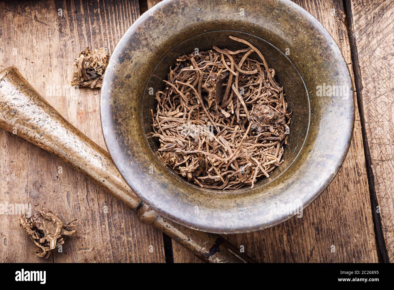 Dried Valerian roots in old bronze mortar.Valerian root for medical use ...