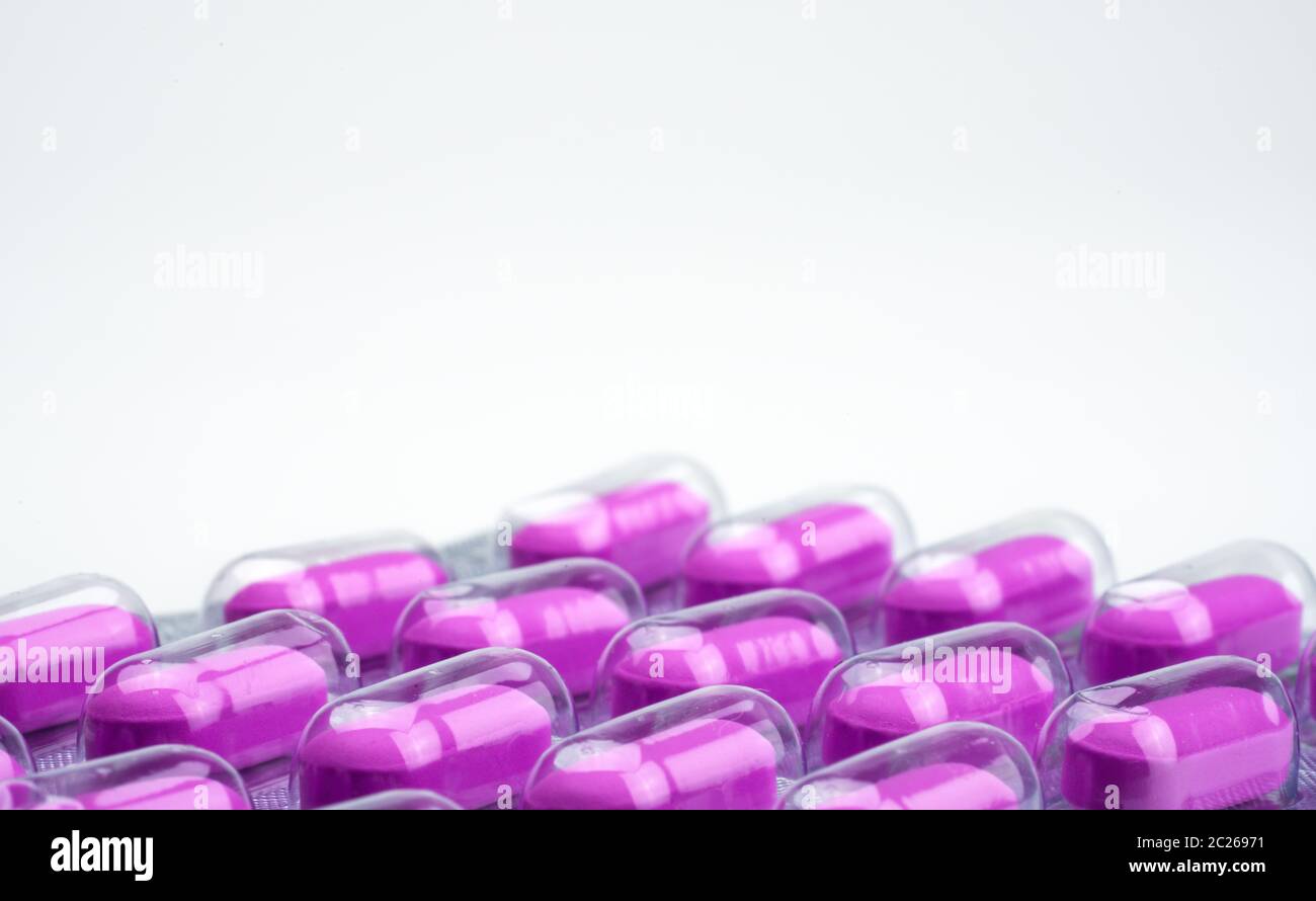 Macro shot of purple caplets pills in blister pack on white background ...