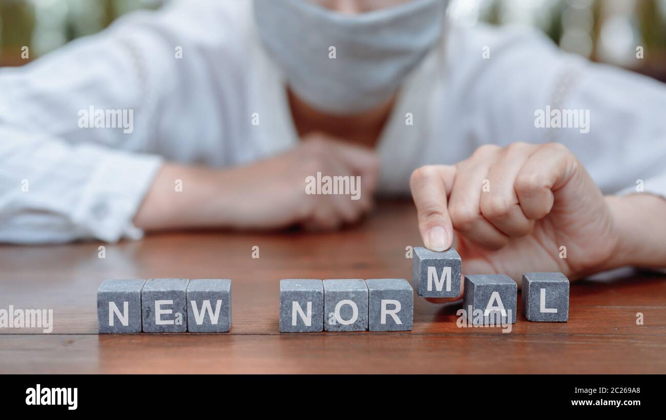Woman with cube text for new normal life concept. Turn to next normal ...