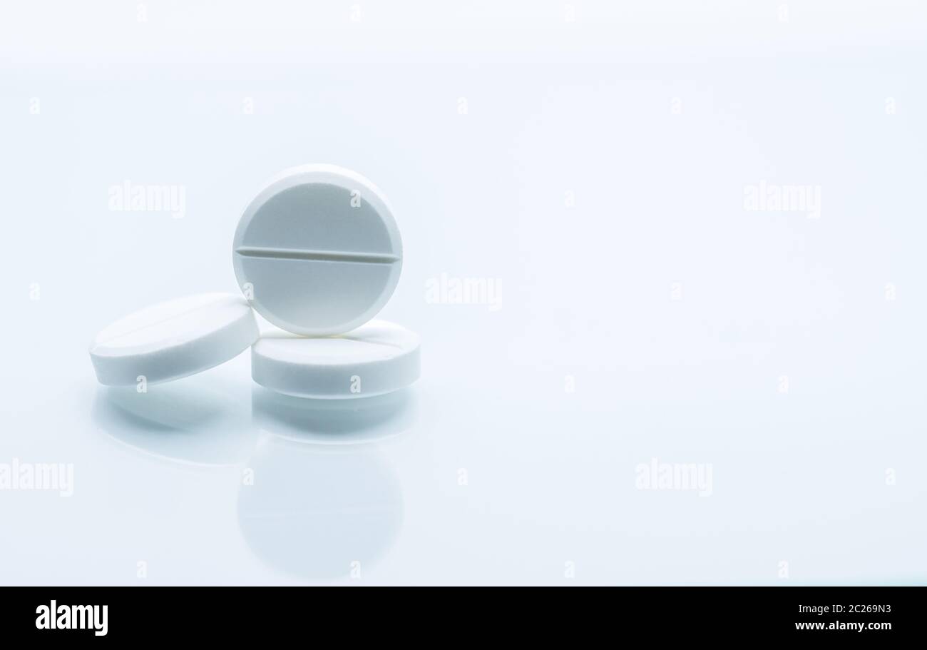 Macro shot of three white chewable tablets on white background with ...