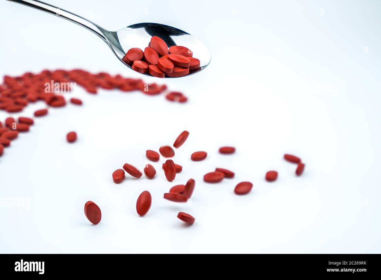 Iron tablets in spoon isolated on white background with copy space for ...