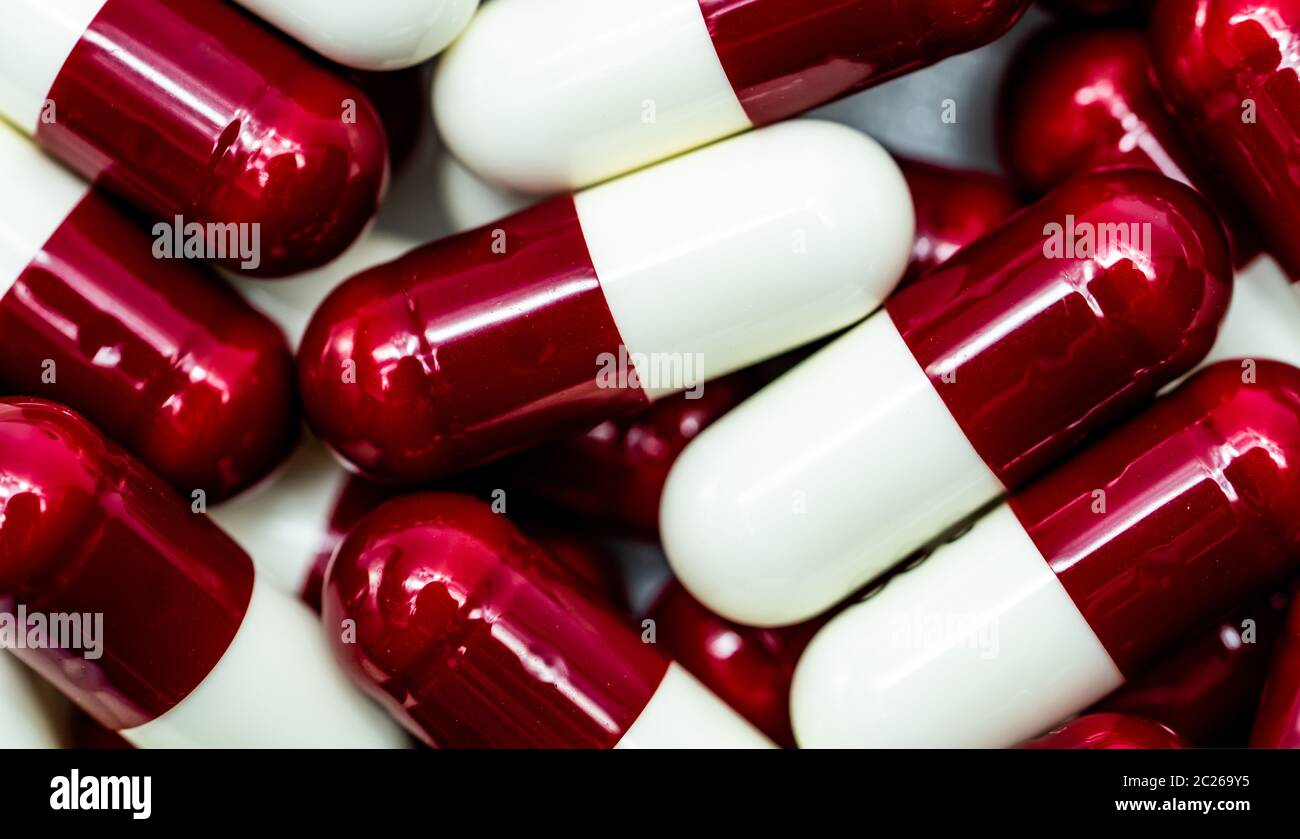 Top view of red and white capsule pills on white background ...