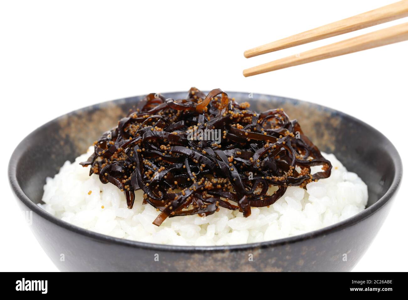 Japanese tsukudani of konbu with cooked white rice on white background ...