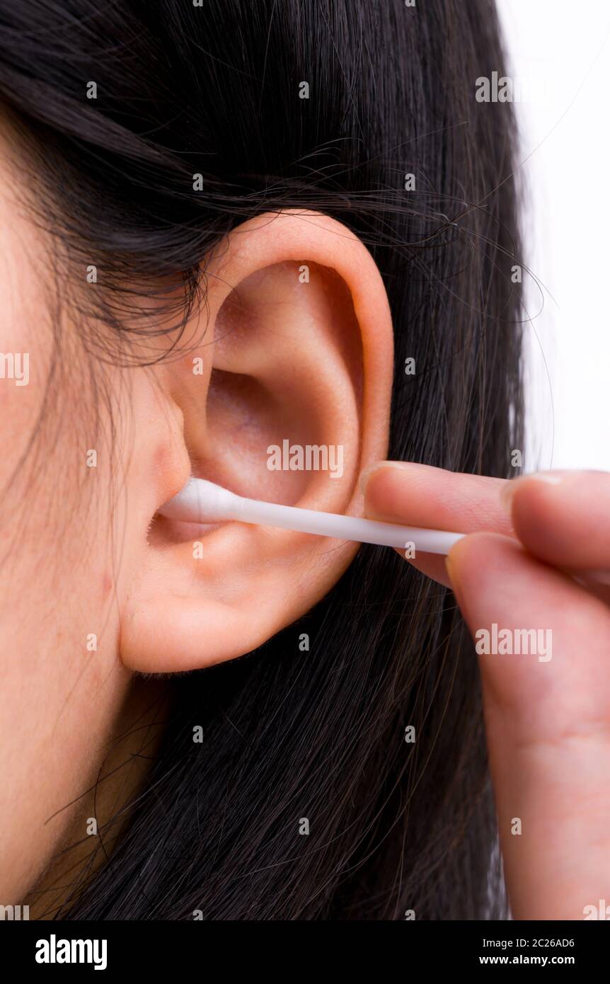 Woman with black hairs is cleaning her ears with white cotton bud ...