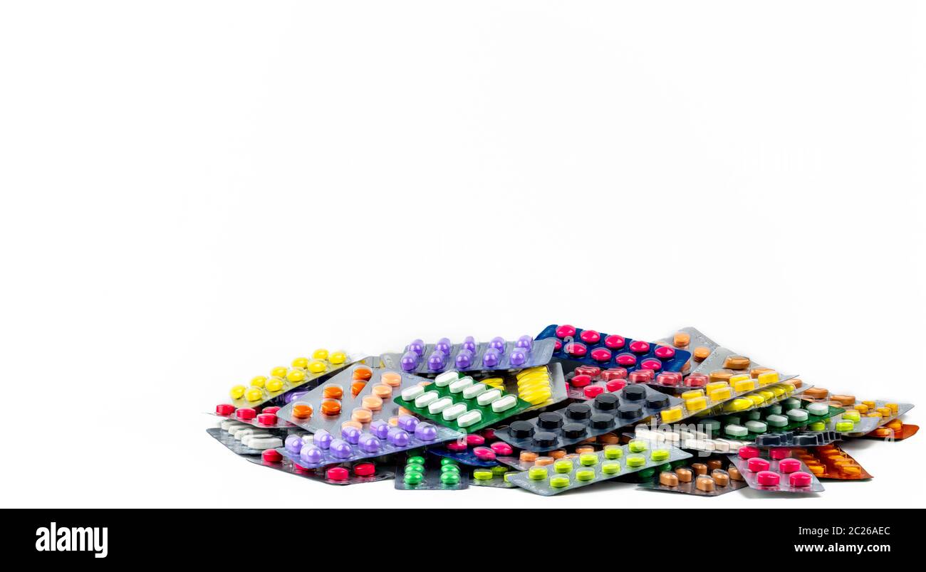 Pile of tablet pills isolated on white background. Yellow, purple ...