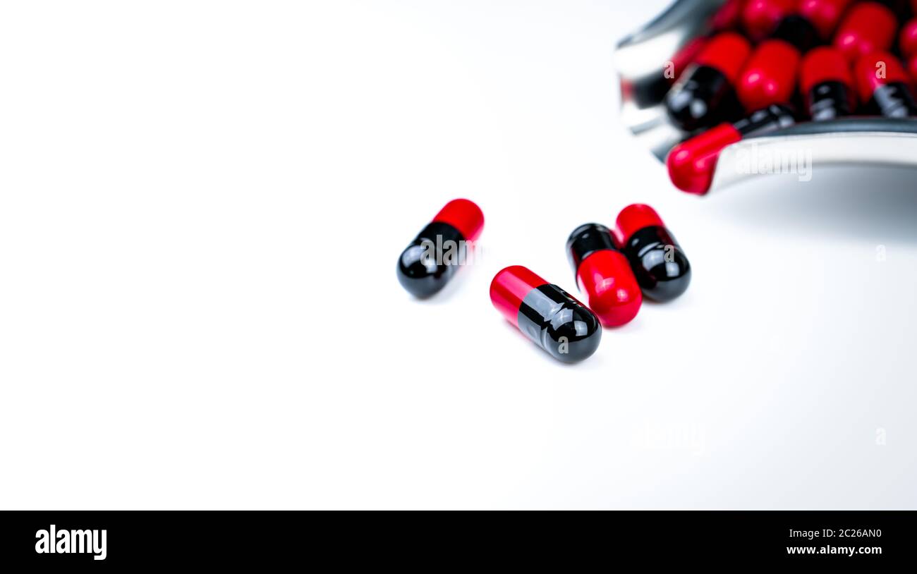 Red and black capsule pills on drug tray. Antibiotics drug resistance ...