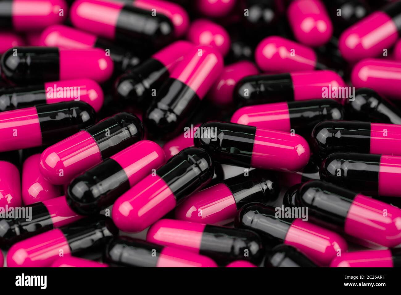 Pile of pink-black capsule pills. Antibiotics resistance. Drug use with ...