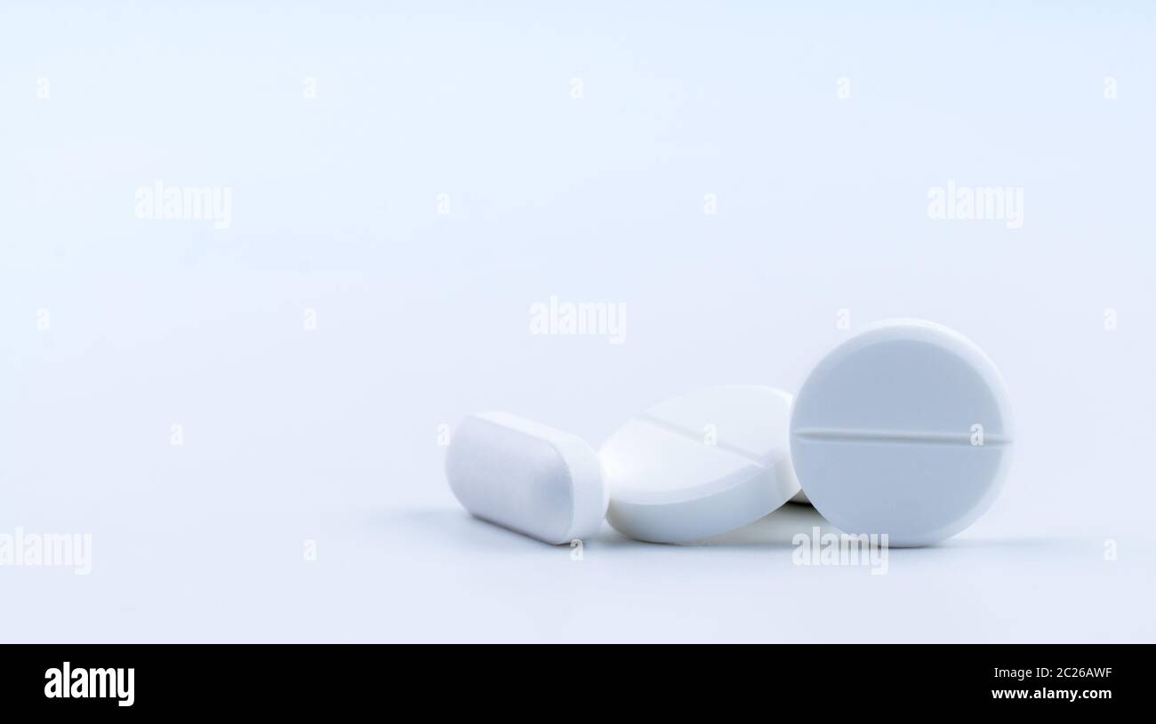 Pile of white round and oblong shape tablet pills isolated on white ...