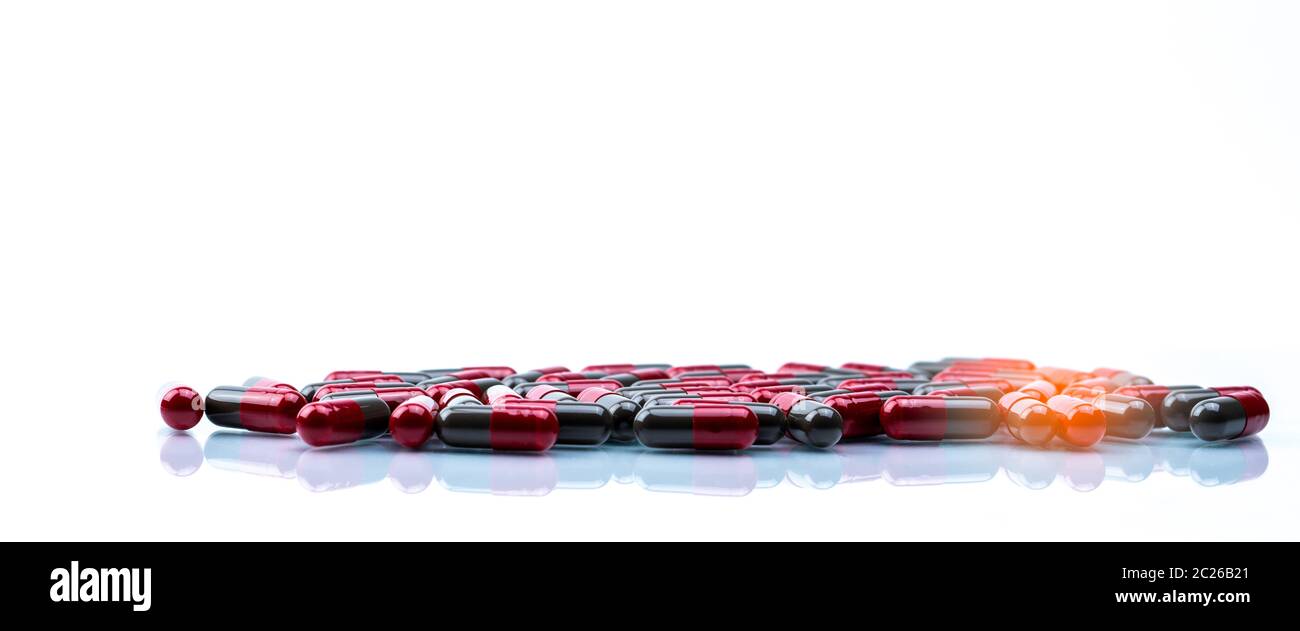 Pile of red and grey capsule pills isolated on white background with ...