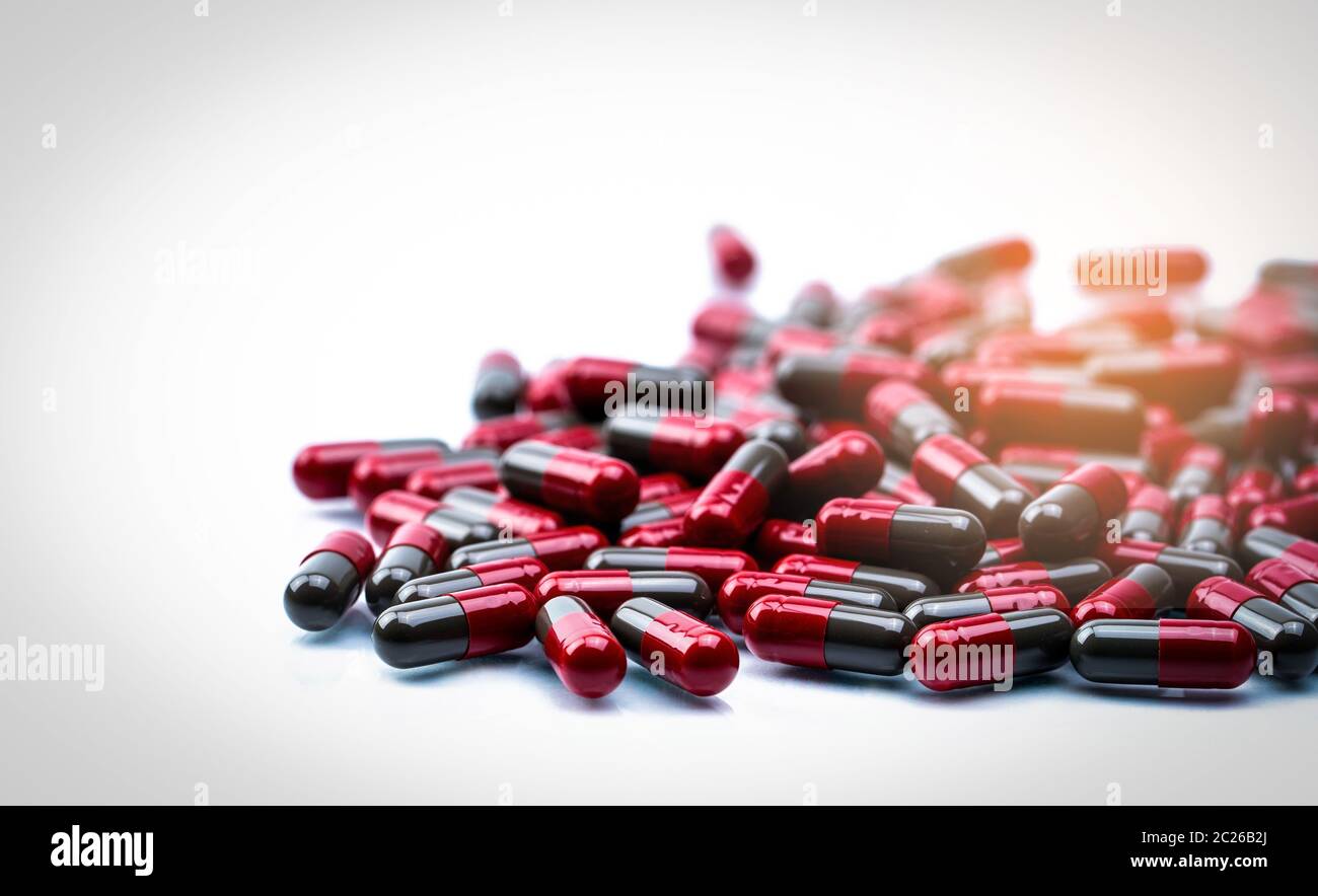 Pile of red and grey capsule pills isolated on white background with ...
