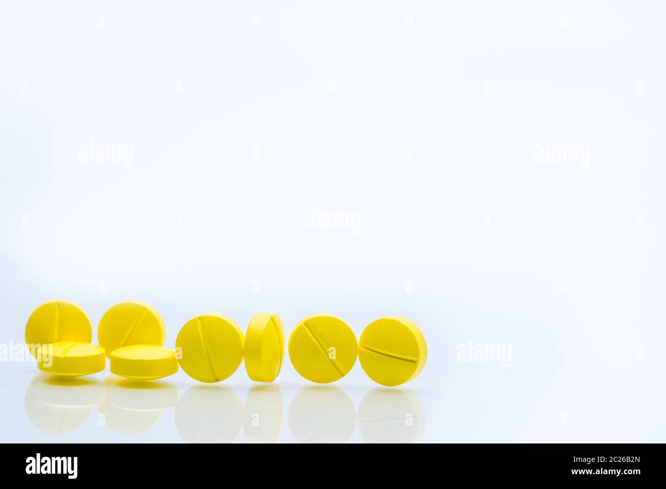 Yellow tablets pills isolated on white background with copy space. Pile ...