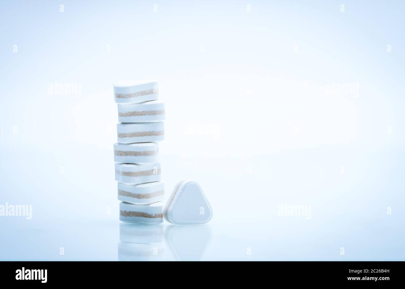 Macro shot of triangle shape tablet pills. Three layers tablet pills ...