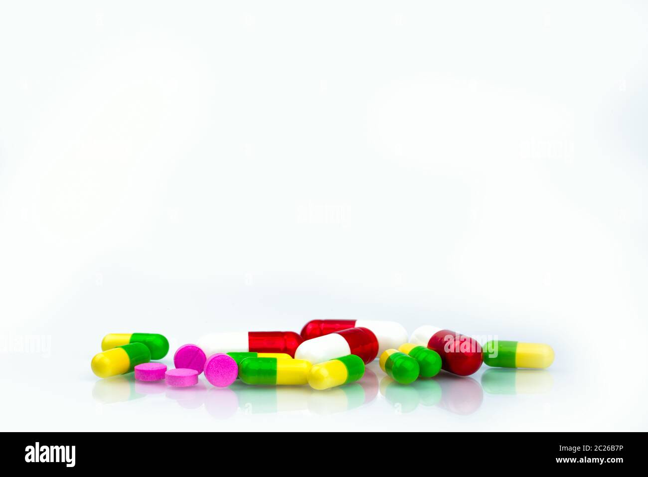 Pile of colorful capsule and tablets pills on white background with ...
