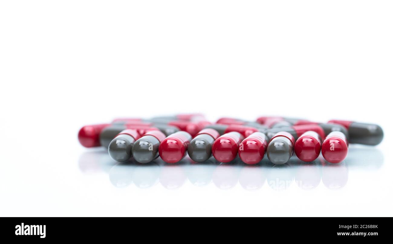 Macro shot detail of red and grey capsule pills isolated on white ...