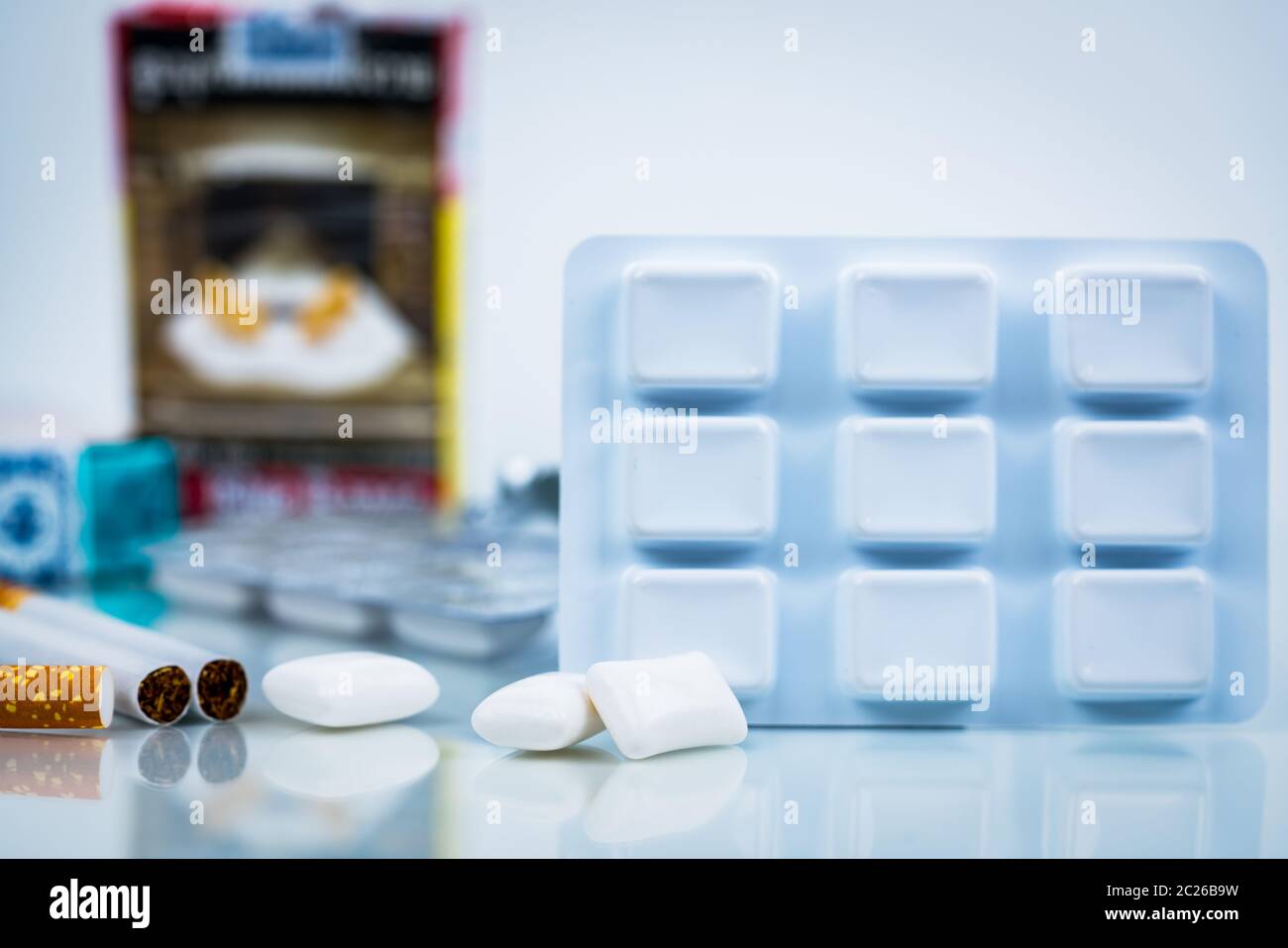 Nicotine chewing gum in blister pack on blurred background of cigarette ...