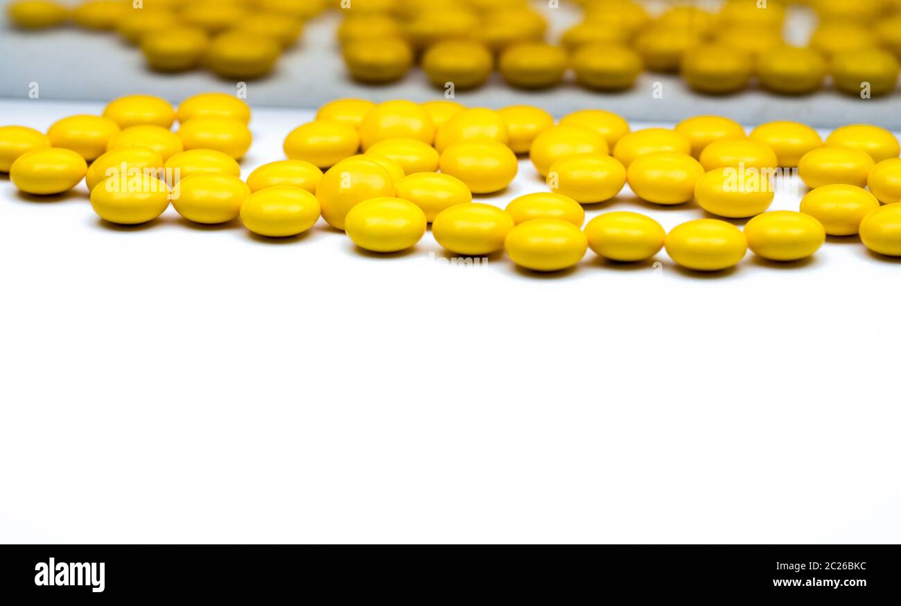 Macro shot detail of yellow round sugar coated tablets pills on blurred ...