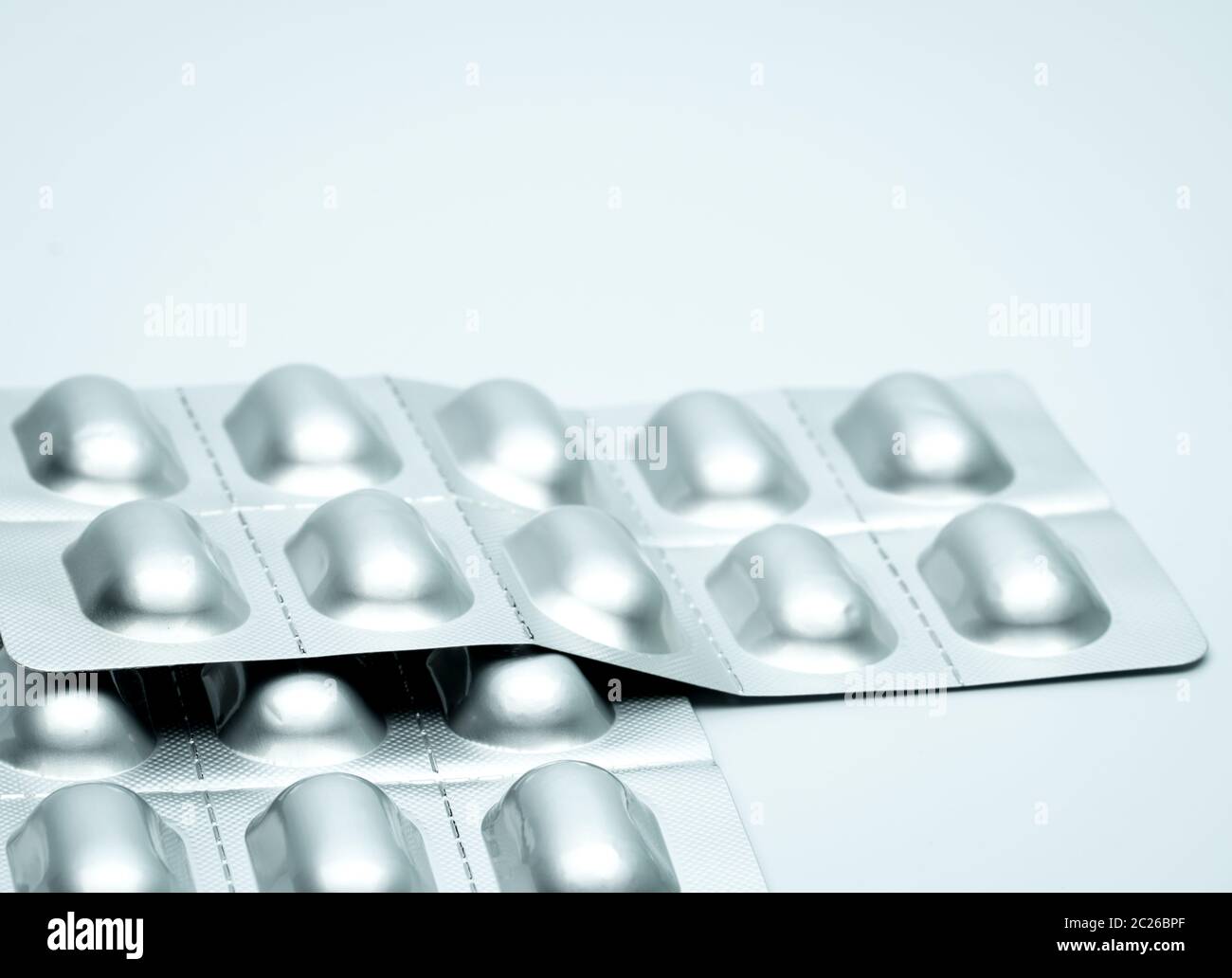Tablet pills in silver aluminium blister pack packaging on blurred ...