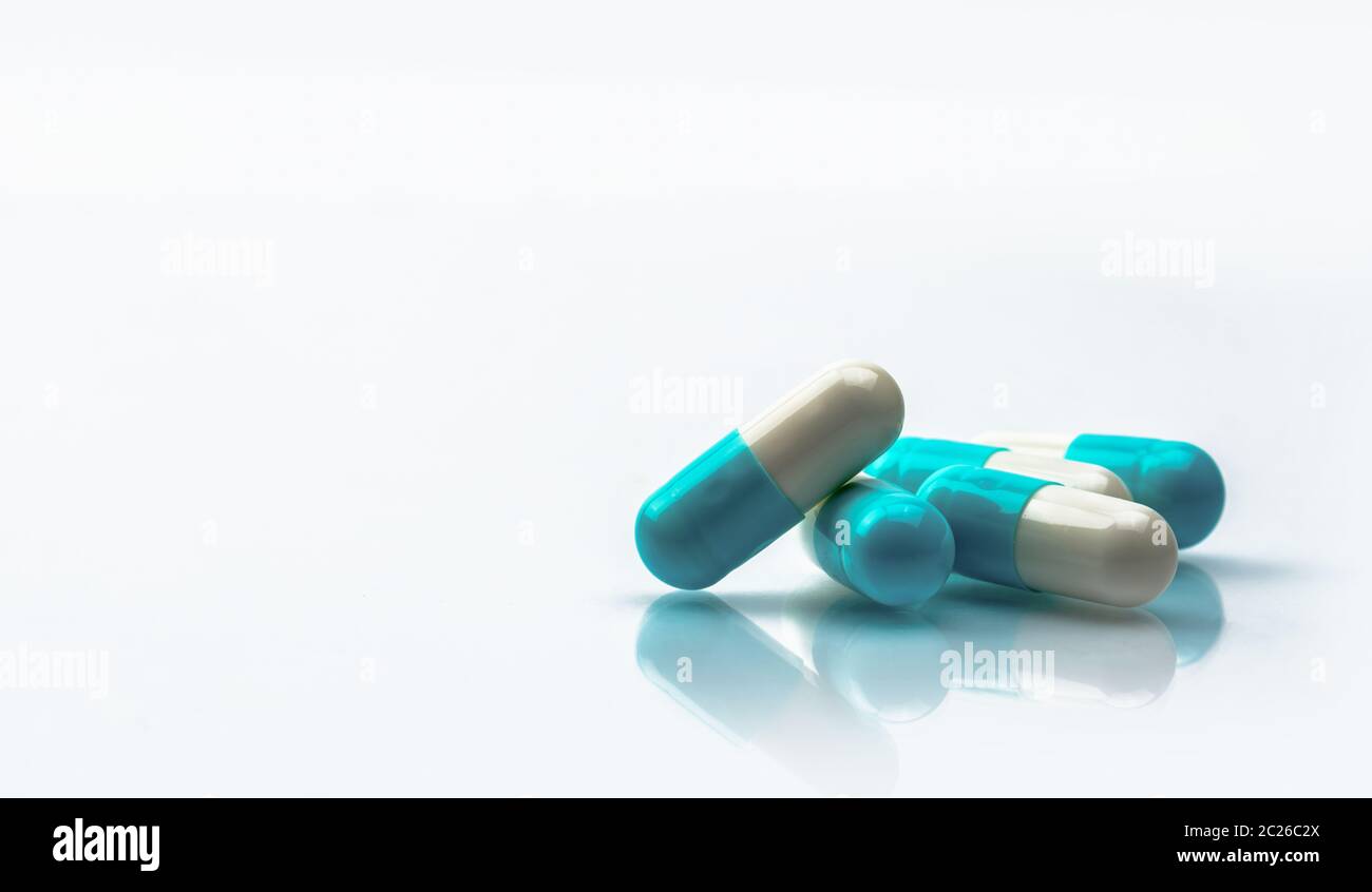 Blue and white capsules pill isolated on white background with shadow ...