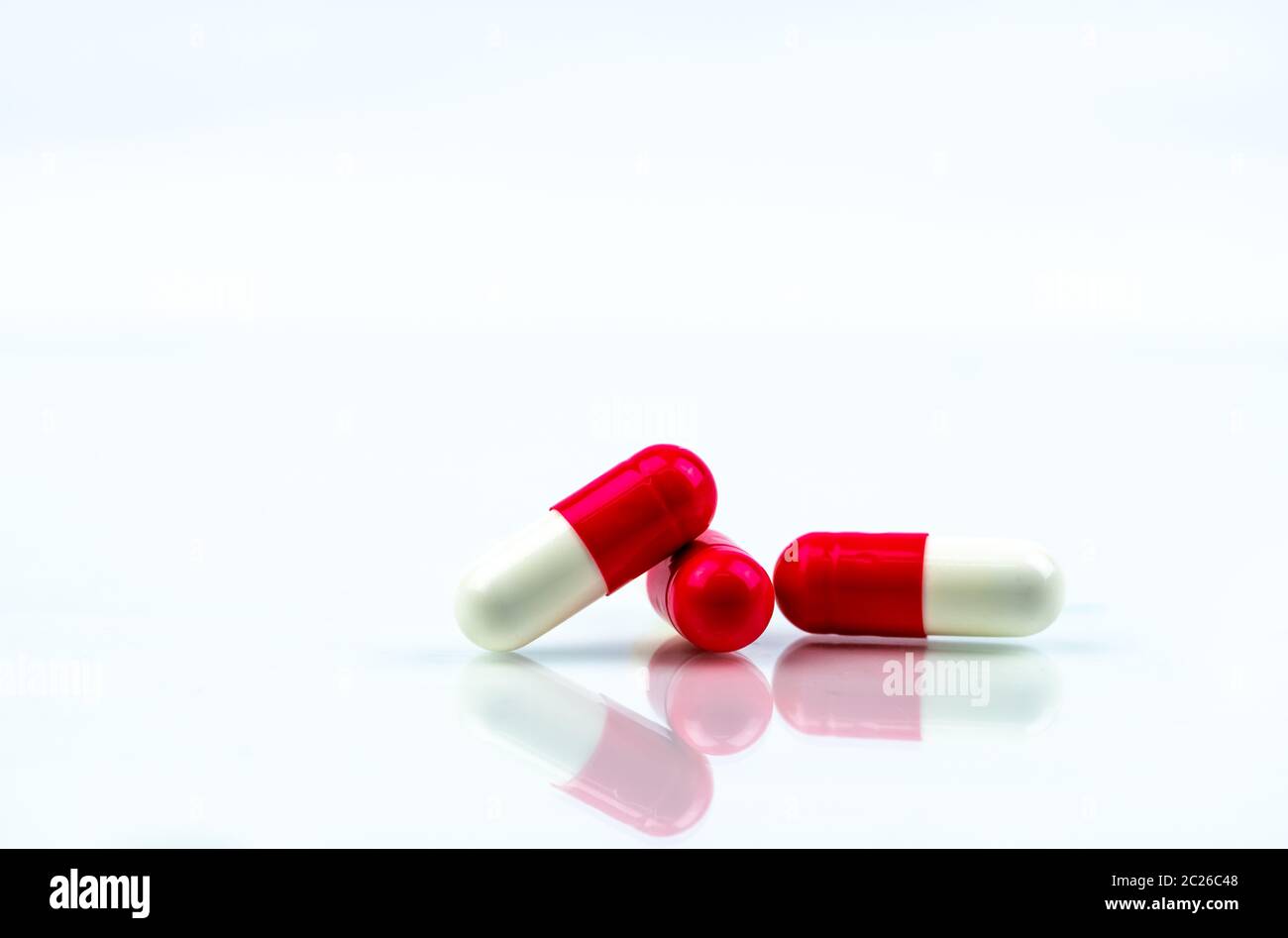 Red and white capsules pill isolated on white background with shadow ...