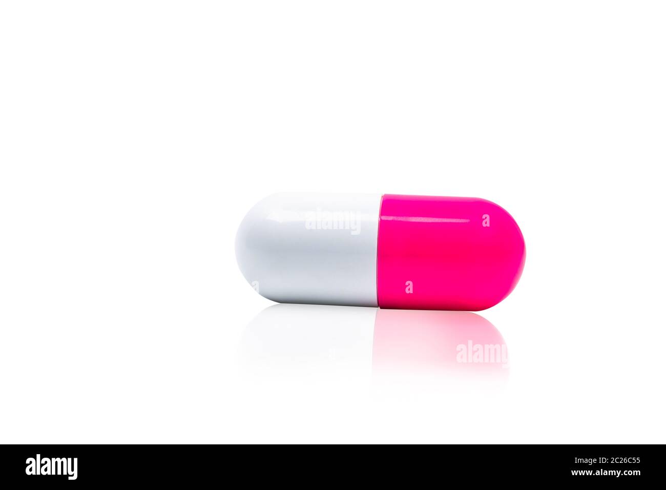 Pink, white capsule pills isolated on white background with shadow and ...