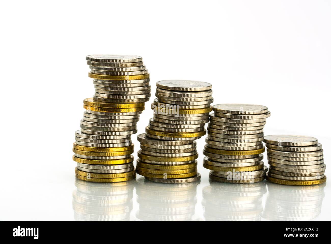 Macro shot detail of golden and silver color coin stacks on white ...