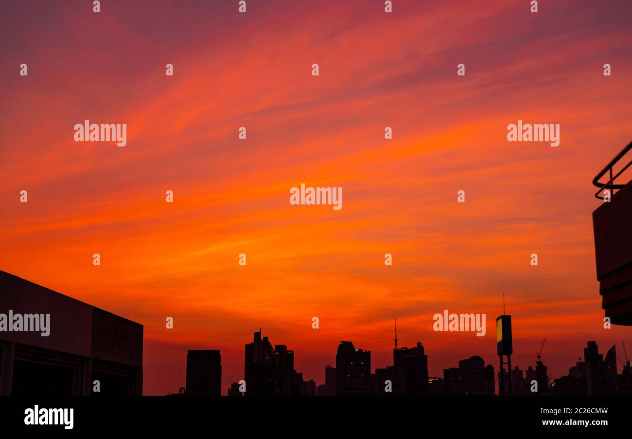 City building in the evening with beautiful red sunset sky and clouds ...