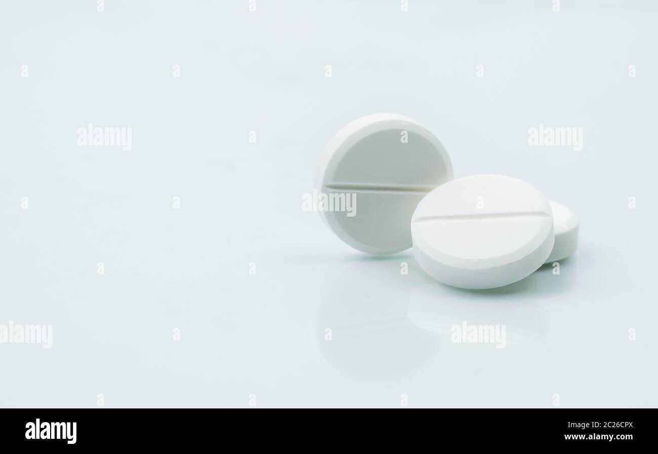 Macro shot of three white chewable tablets on white background with ...