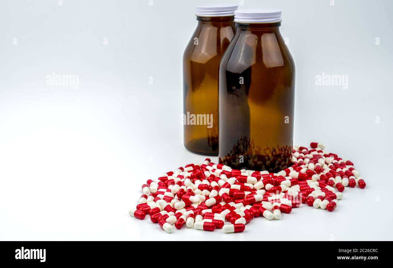 Colorful of antibiotic capsules pills with two amber glass bottles ...