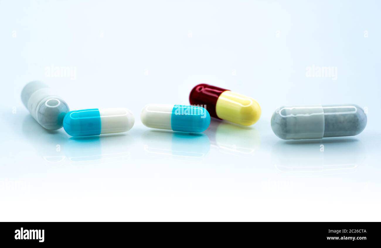 Colorful capsule pills on white background. Pharmaceutical industry ...