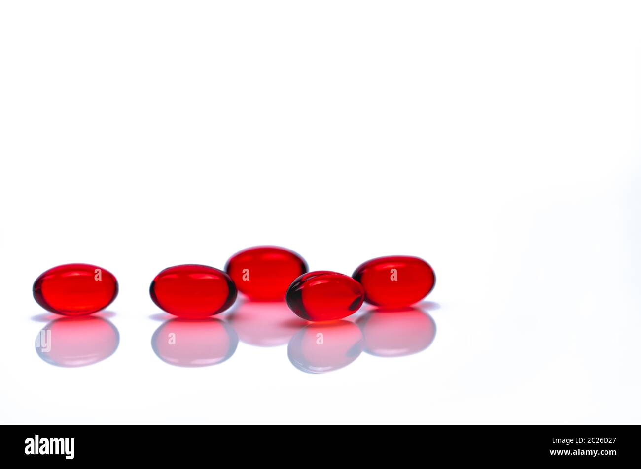 Red soft gel capsule pills isolated on white background. Pile of red ...