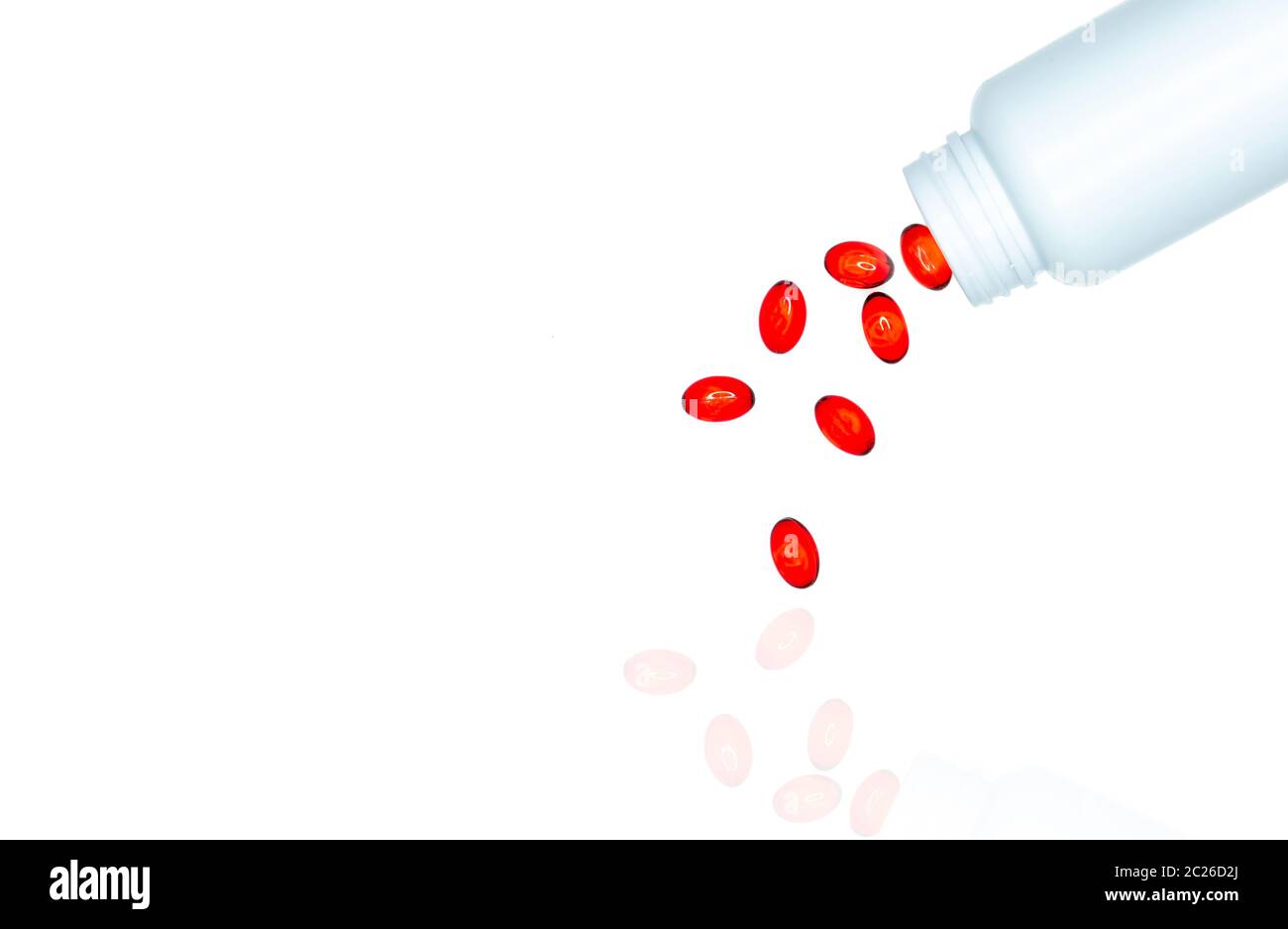 Pour red soft gel capsule pills out of drug bottle isolated on white ...