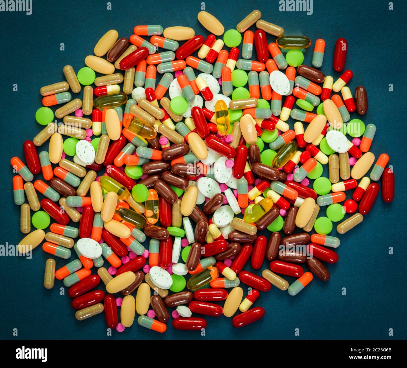 Pile of colorful tablets and capsules pills on blue background ...