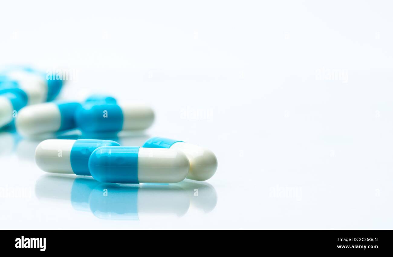 Pile of blue and white capsules pills isolated on white background with ...