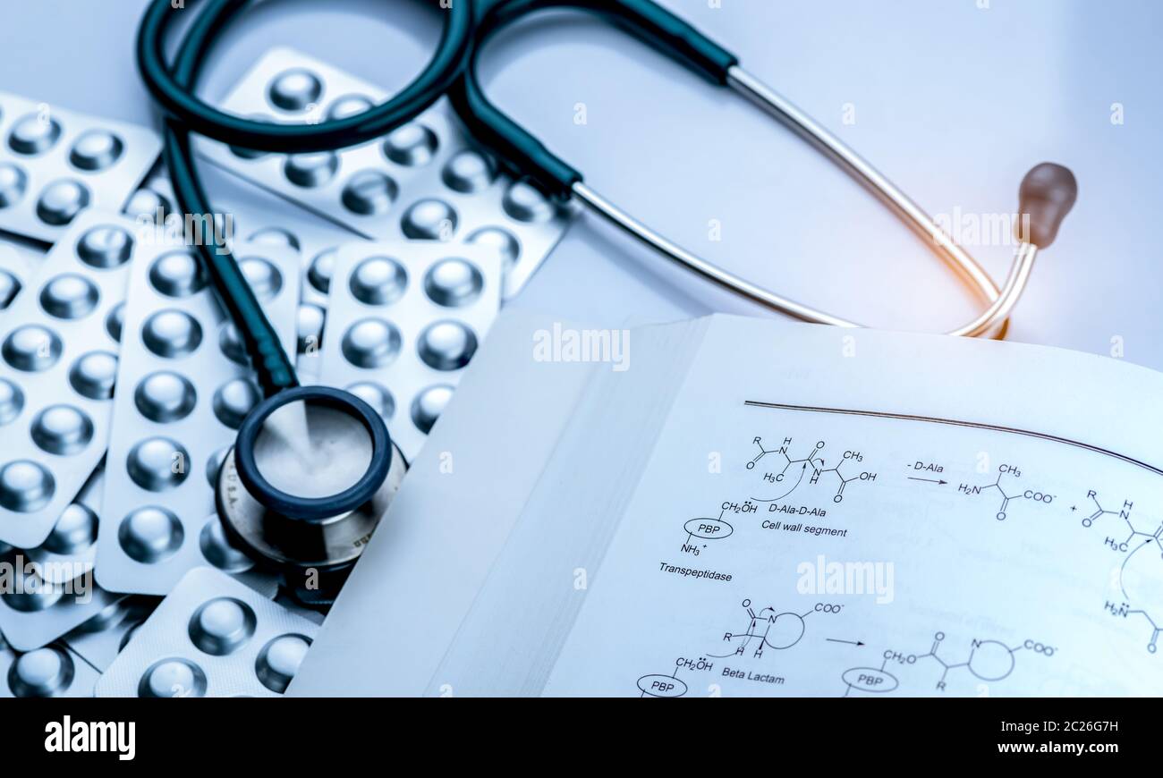 Pile of tablets pill in blister pack with drug structure book and ...