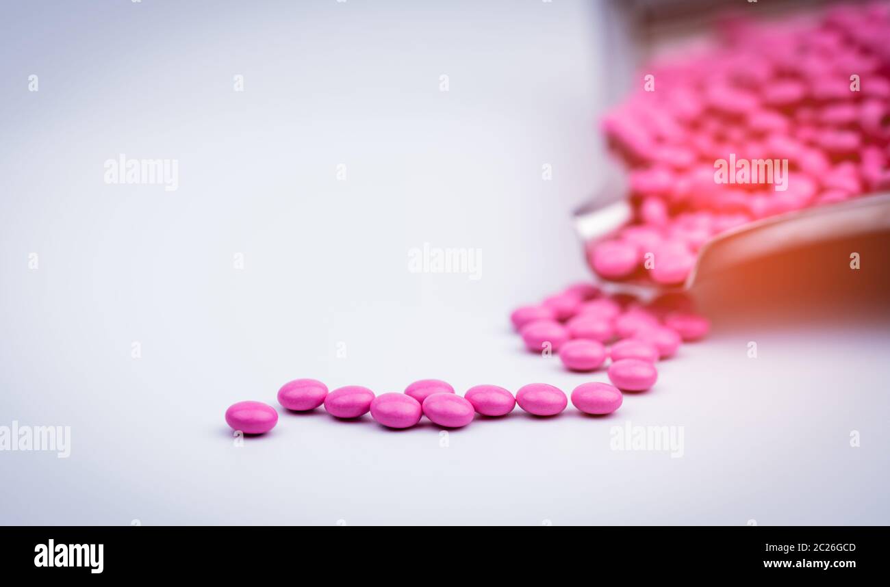 Pile of pink round sugar coated tablets pills on drug tray with copy ...