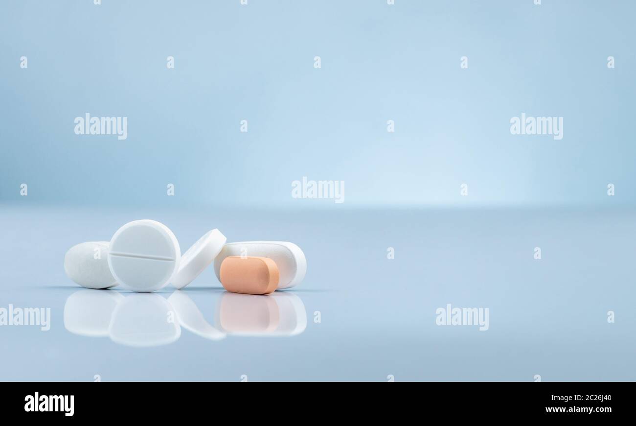 Pharmacy drugstore product. Pile of orange and white tablets pill on ...