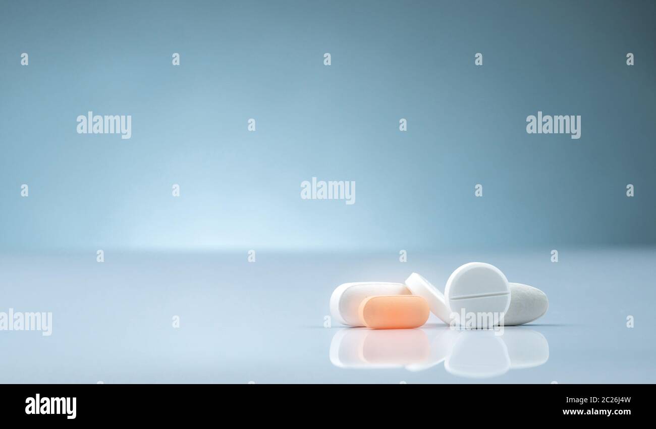 Pharmacy drugstore product. Pile of orange and white tablets pill on ...