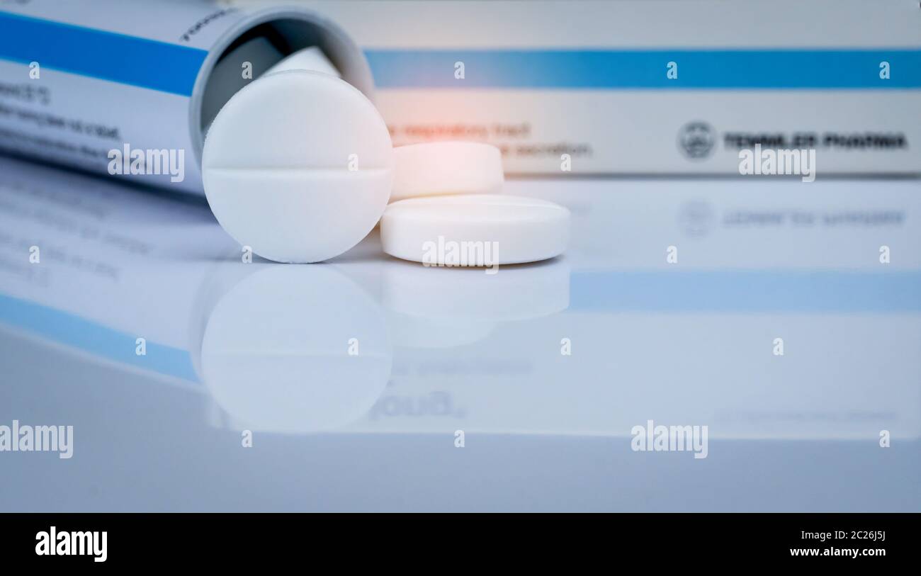 White effervescent tablets on blurred background of tube drug container ...